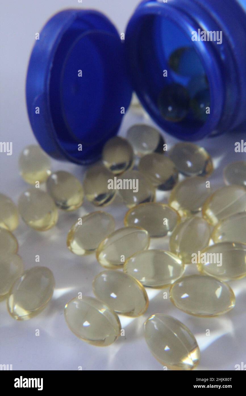 Blue bottle of vitamin capsules omega 3 fish oil with some spilling out ...