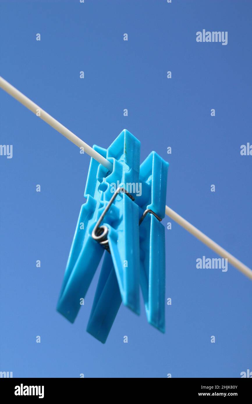 Two blue plastic cloths peg on a washing line on a hot summers day with ...
