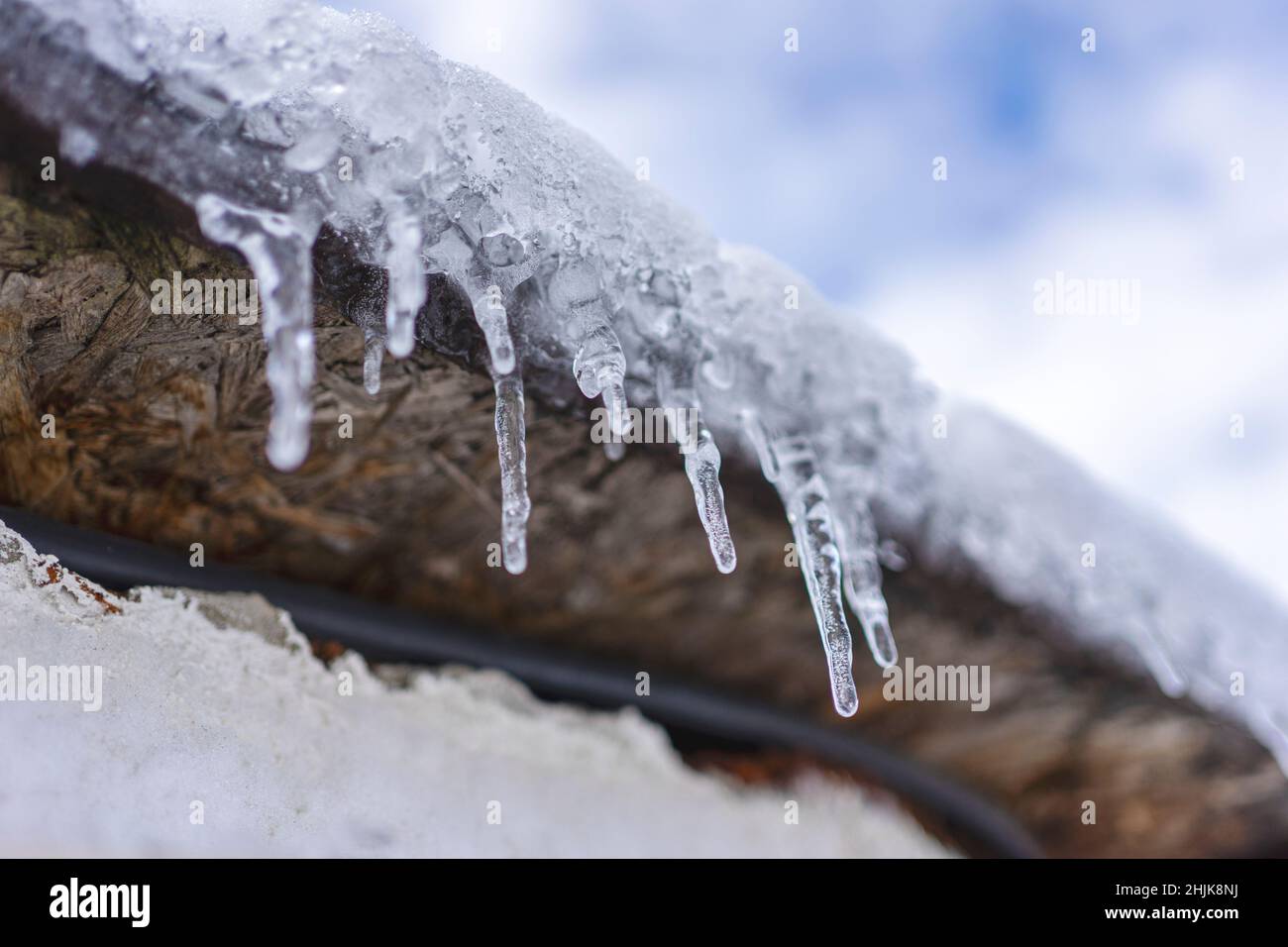 Small Icicles hang from the wooden roof Stock Photo - Alamy