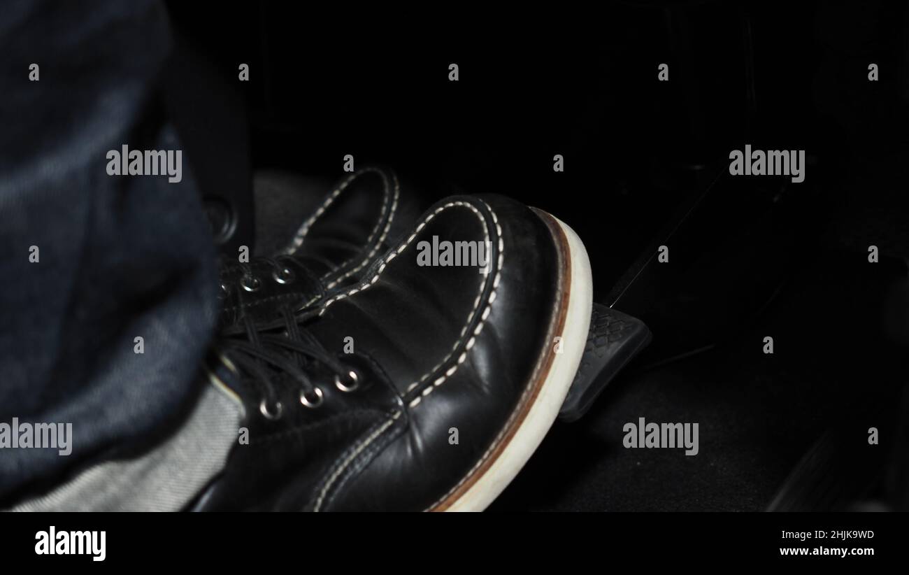 Accelerate and Brake. Foot pressing foot pedal of a car to drive ahead ...