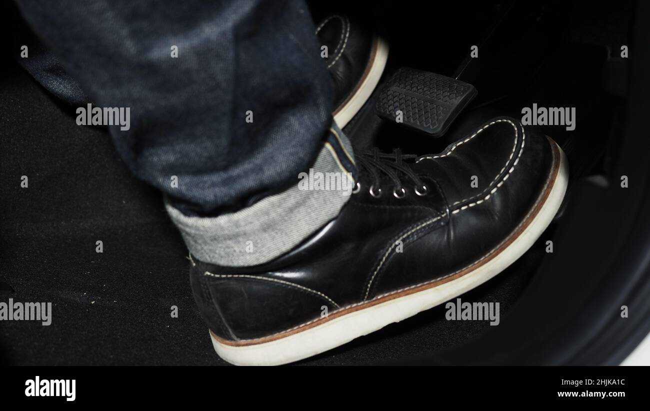 Accelerate and Brake. Foot pressing foot pedal of a car to drive ahead ...