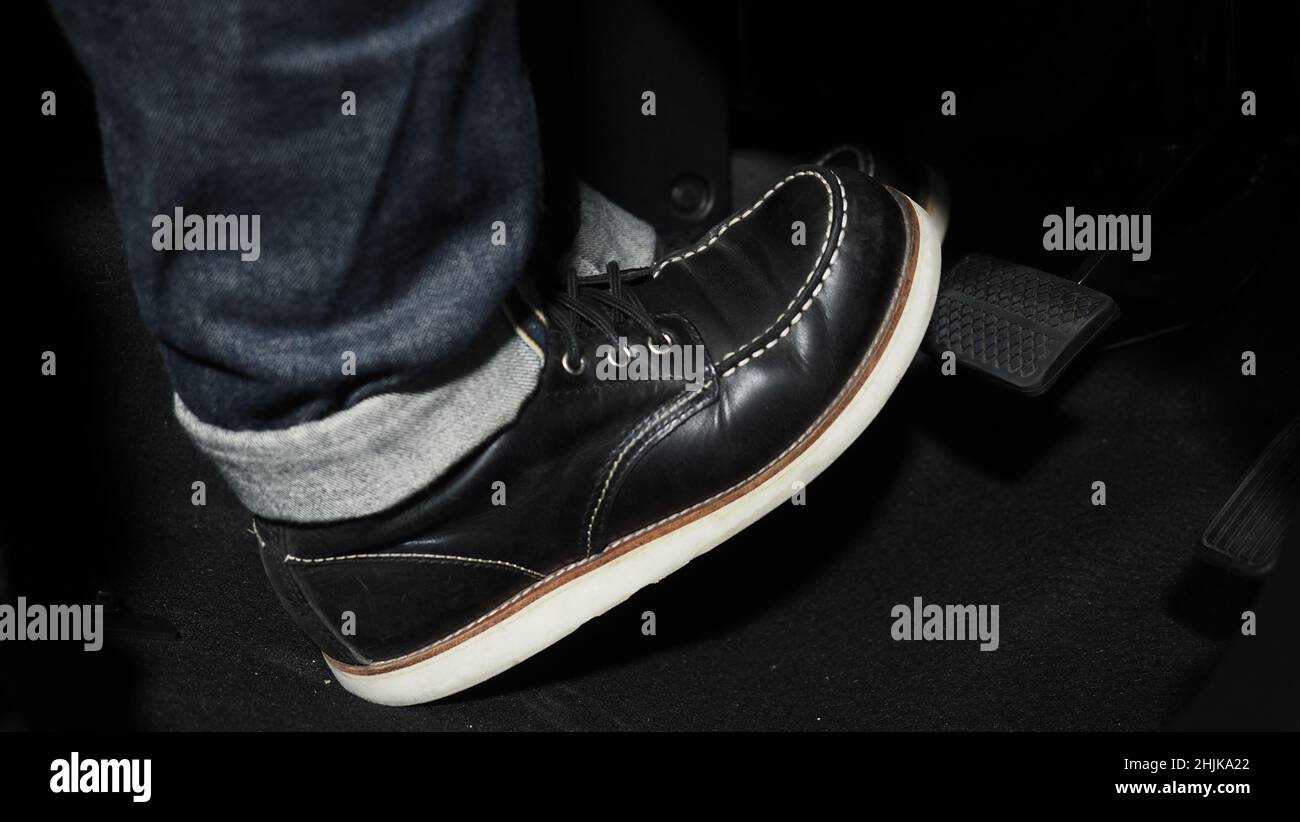 Accelerate and Brake. Foot pressing foot pedal of a car to drive ahead ...