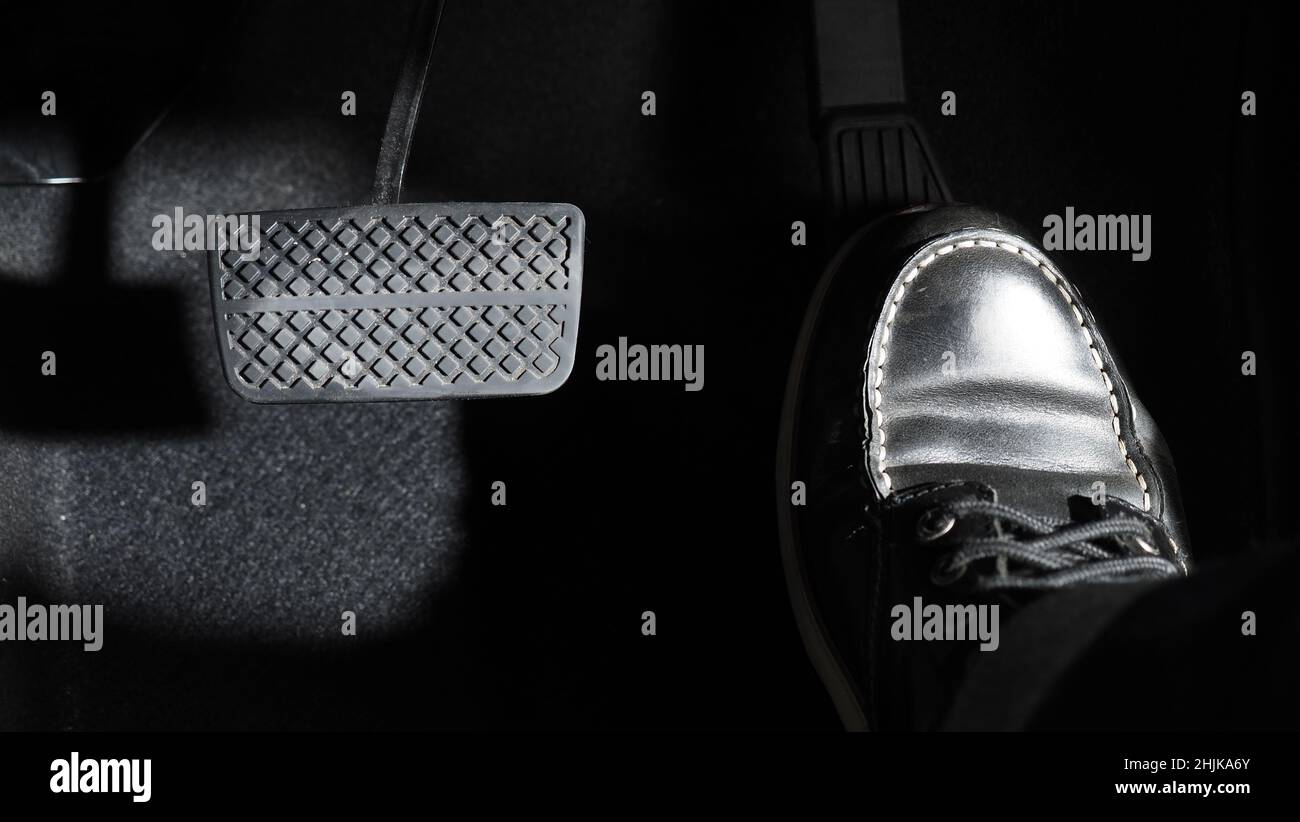 Accelerate and Brake. Foot pressing foot pedal of a car to drive ahead ...
