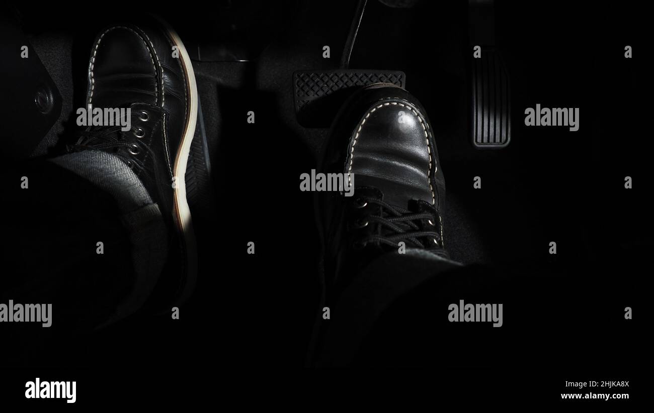 Accelerate and Brake. Foot pressing foot pedal of a car to drive ahead ...