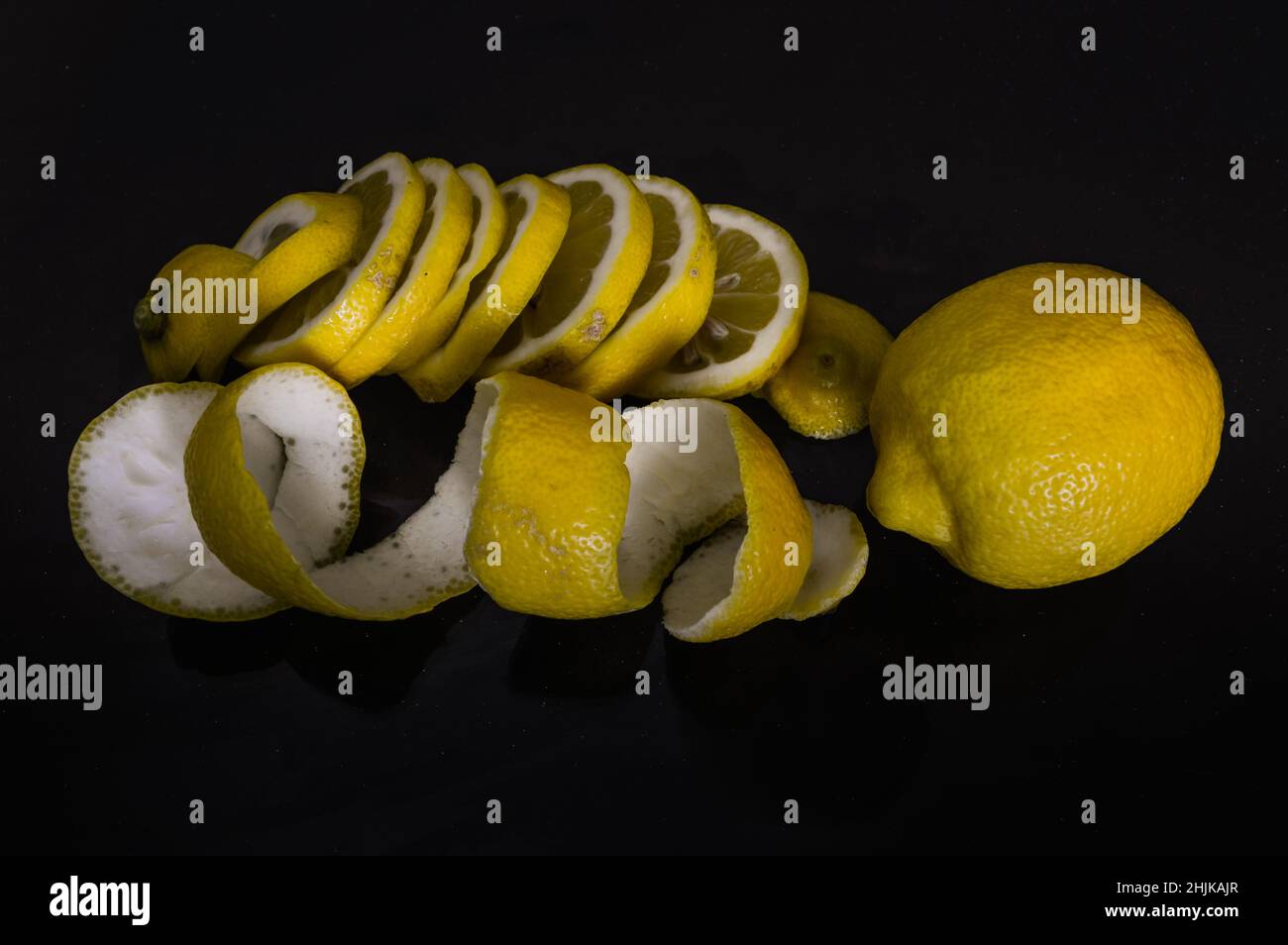 lemon slices and whole lemon peel curled in a spiral and a whole lemon ...