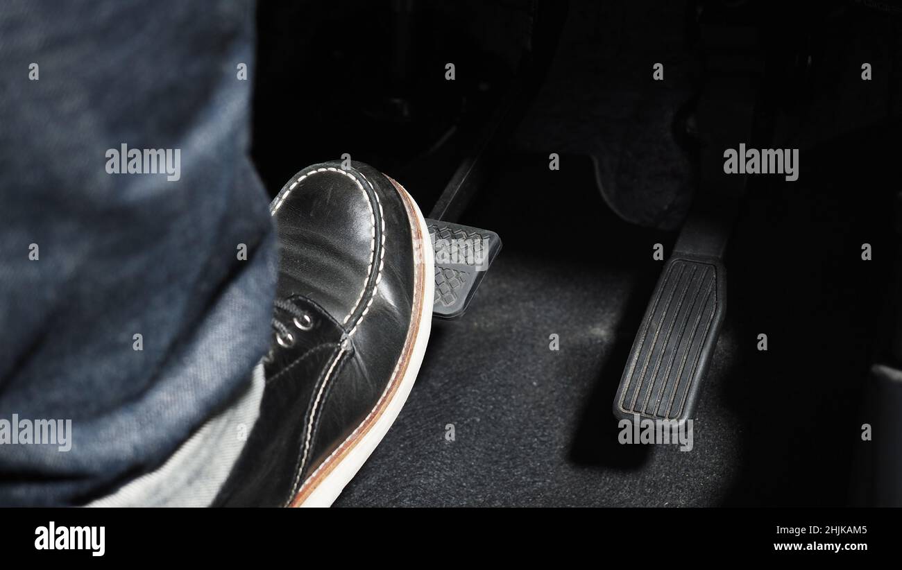 Accelerate and Brake. Foot pressing foot pedal of a car to drive ahead ...
