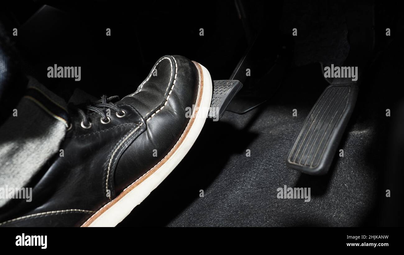 Accelerate and Brake. Foot pressing foot pedal of a car to drive ahead ...