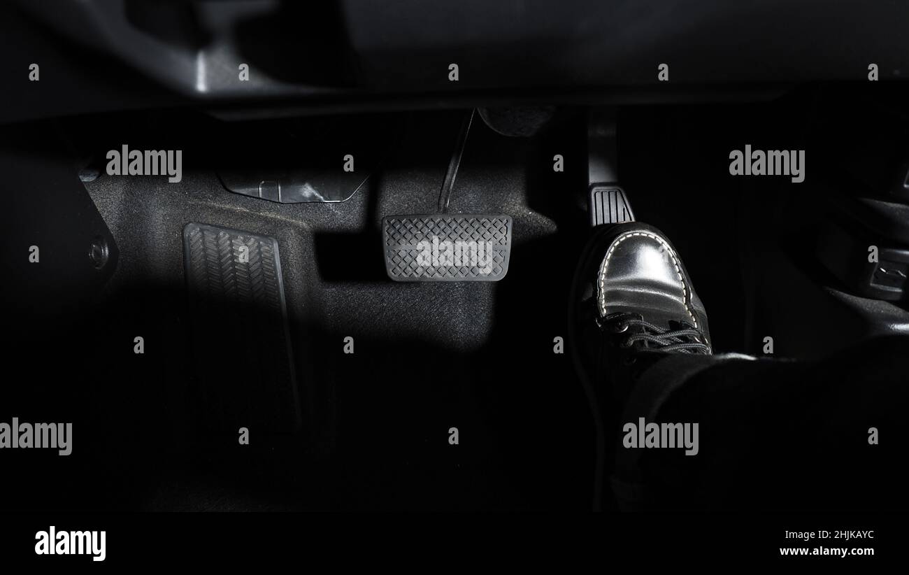 Accelerate and Brake. Foot pressing foot pedal of a car to drive ahead ...
