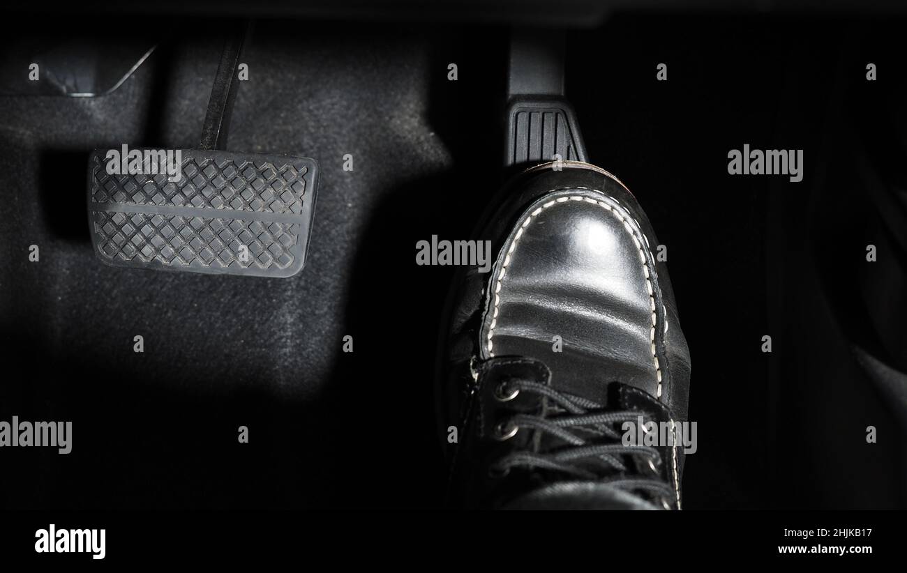 Accelerate and Brake. Foot pressing foot pedal of a car to drive ahead ...