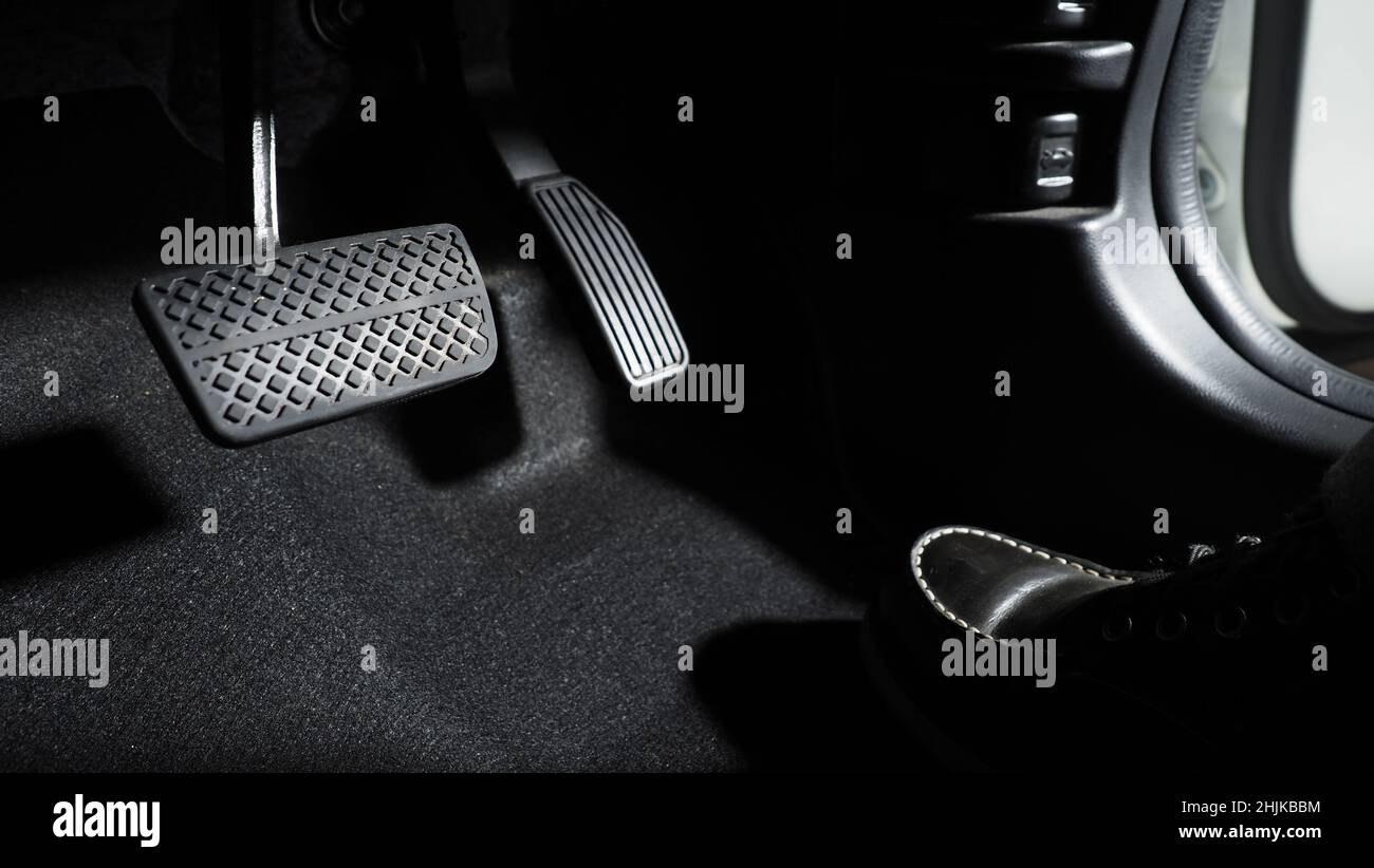 Accelerate and Brake. Foot pressing foot pedal of a car to drive ahead ...
