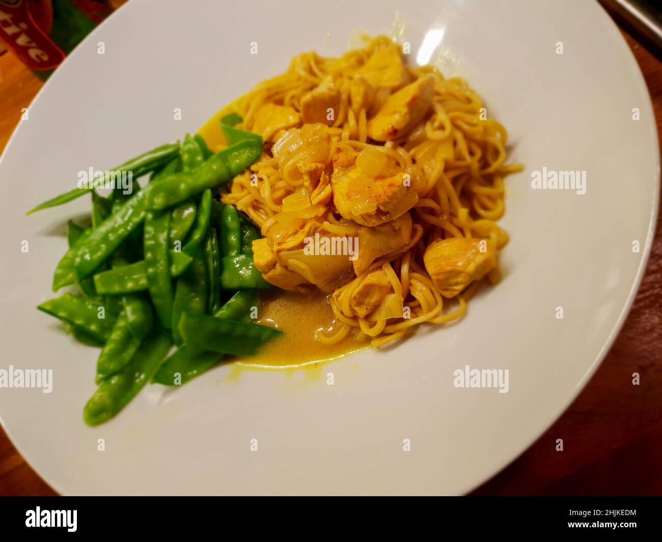 A portion of chicken noodles and green beens on white plate Stock Photo ...