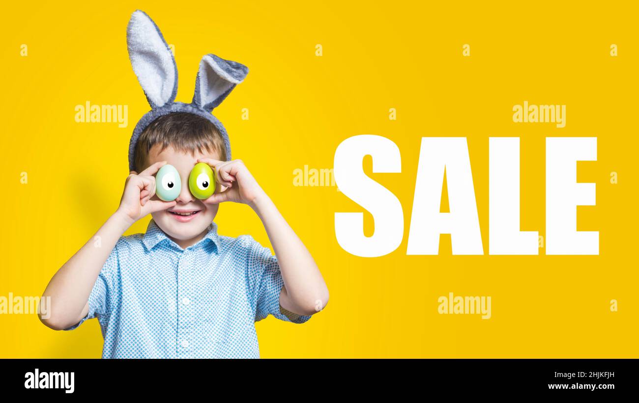 Shocked and surprised child in bunny ears and holding colorful easter ...