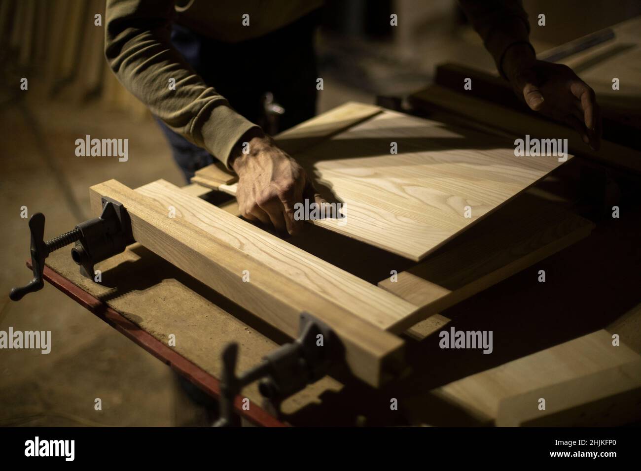 Work with wood. Fixing board. Carpenter installs part. Wood processing ...