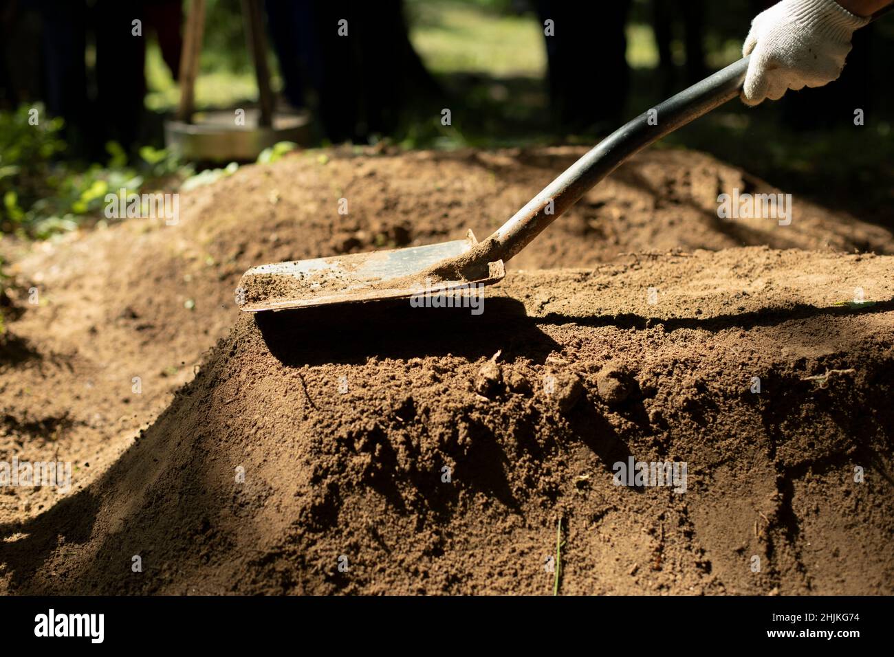 Undertaker strikes grave. Shovel and earth. Man is digging ground. Sand ...