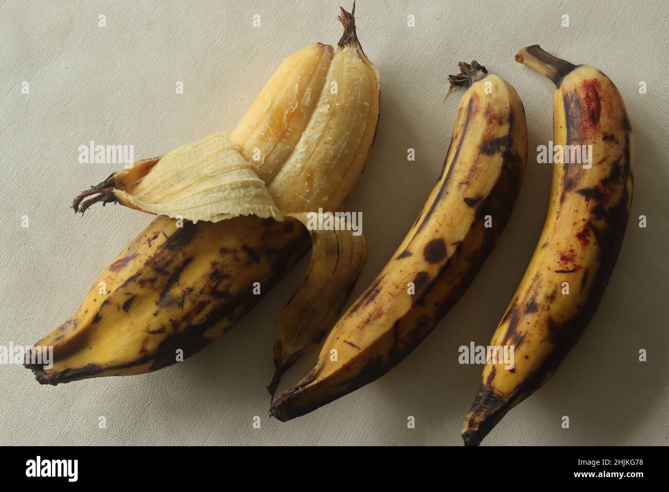 Twin Ripe plantain yellow in colour, ready to eat with skin half peeled ...