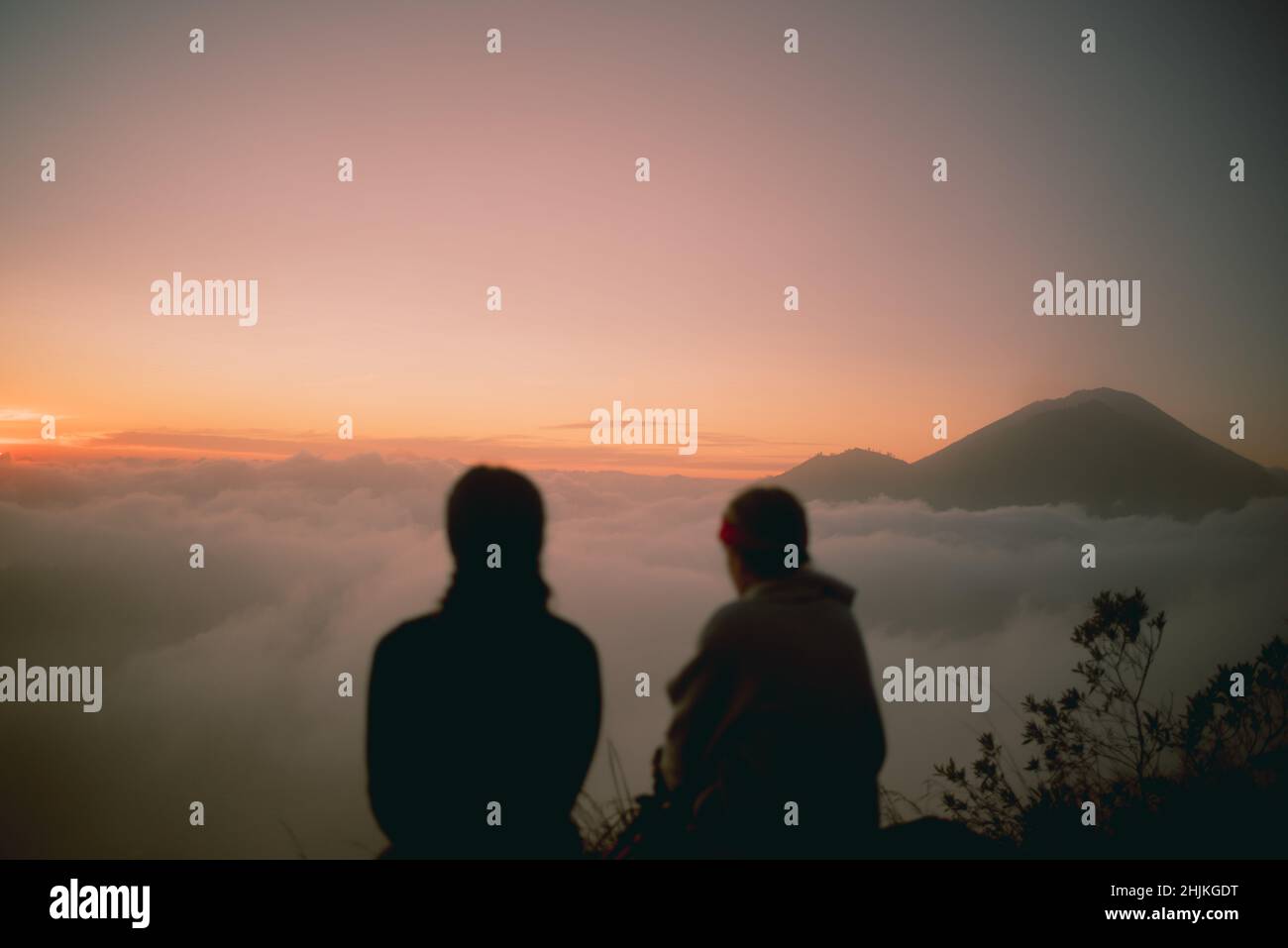 Silhouette of two people watching a sunrise on Mount Batur Stock Photo ...