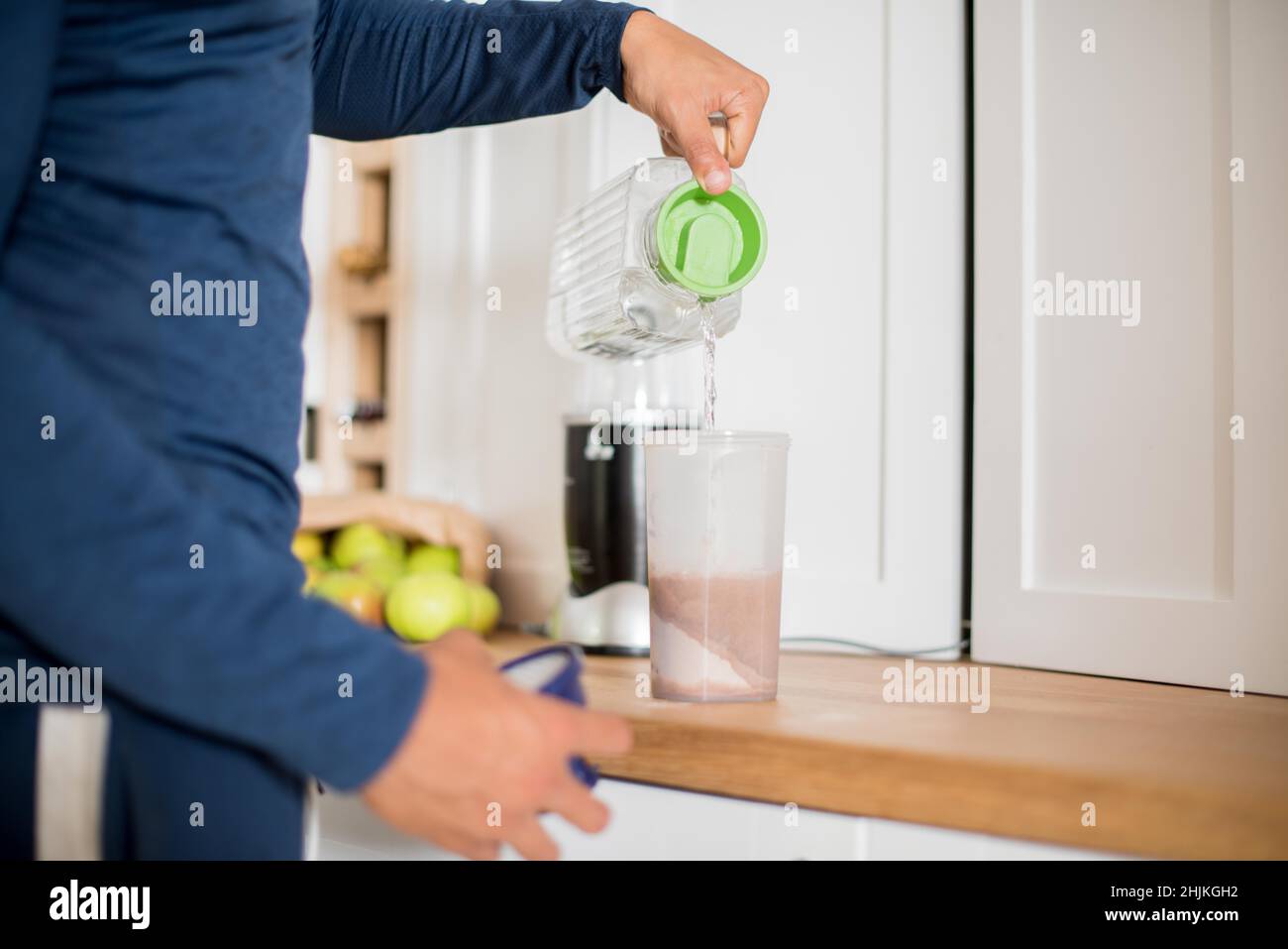 Fit male making himself a protein shake at home Stock Photo - Alamy
