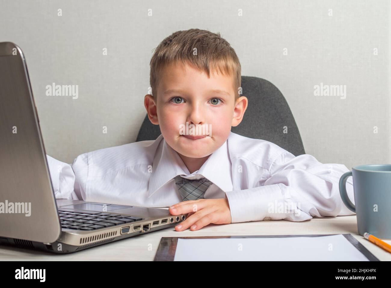 Young business boy is working in the office. A child disguised as a ...