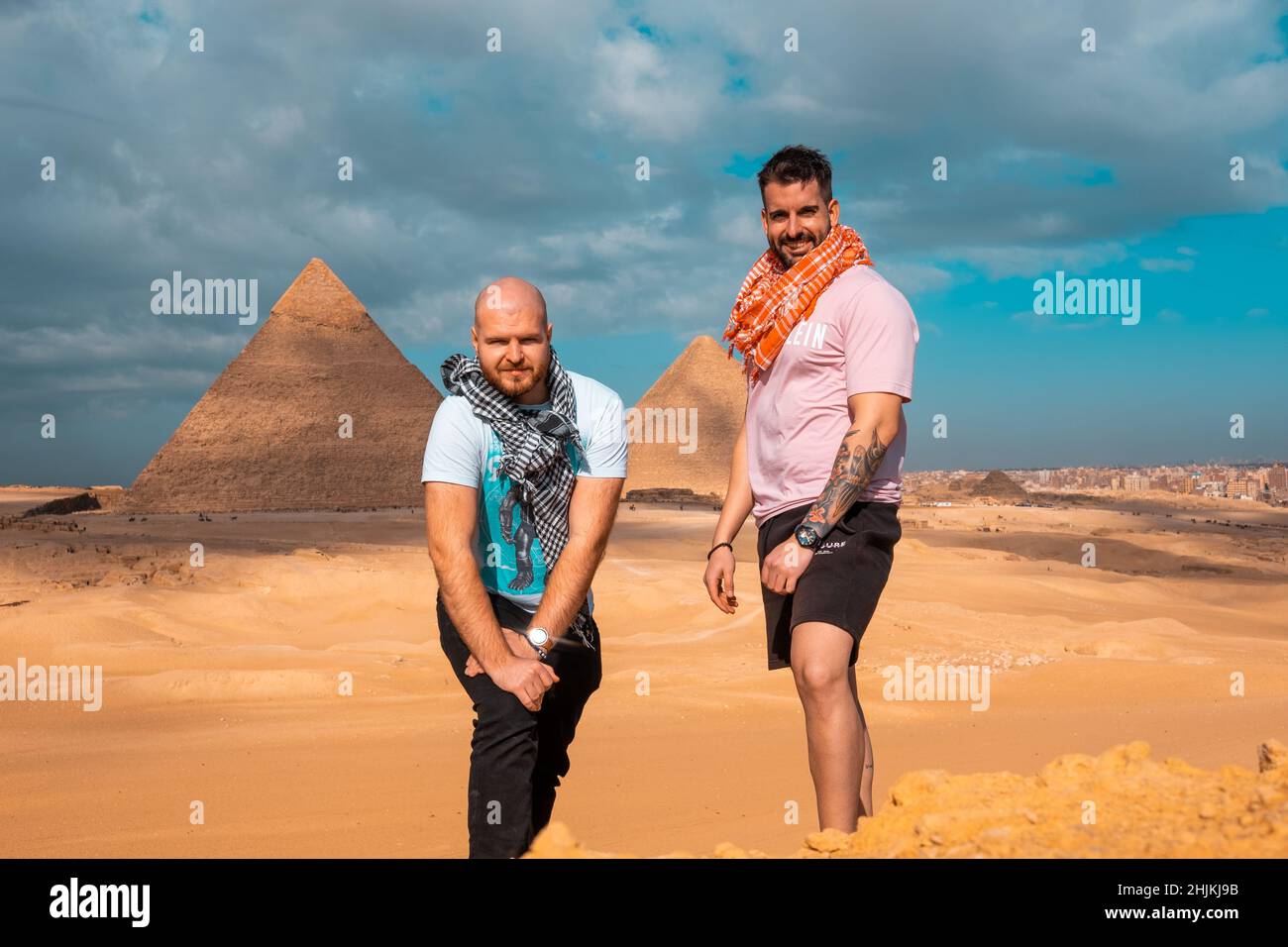 Two men travelers posing in front of the great pyramids of giza in ...