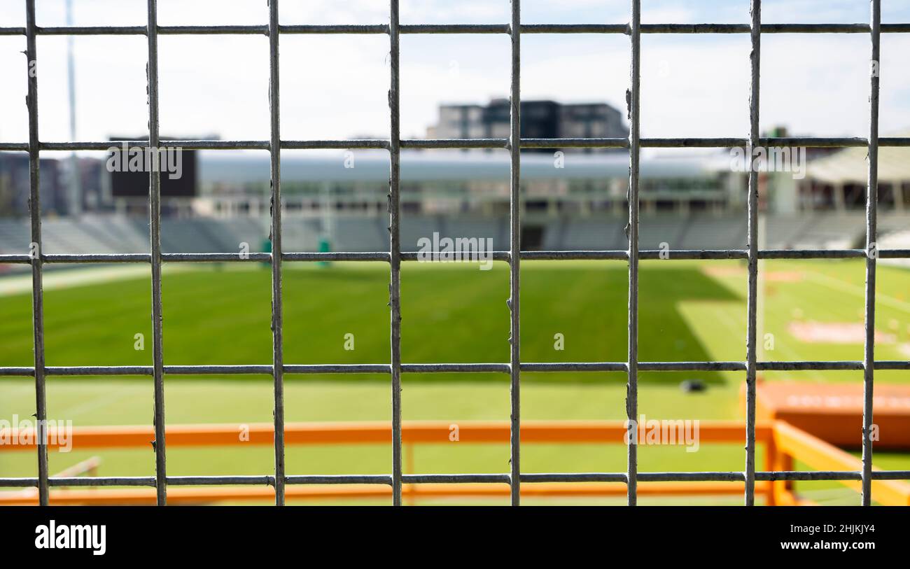 Detail of metal security fence around a running track Stock Photo - Alamy