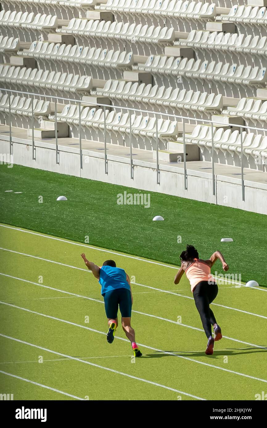 A man and a woman athletes rehearse the start at speed in a stadium ...