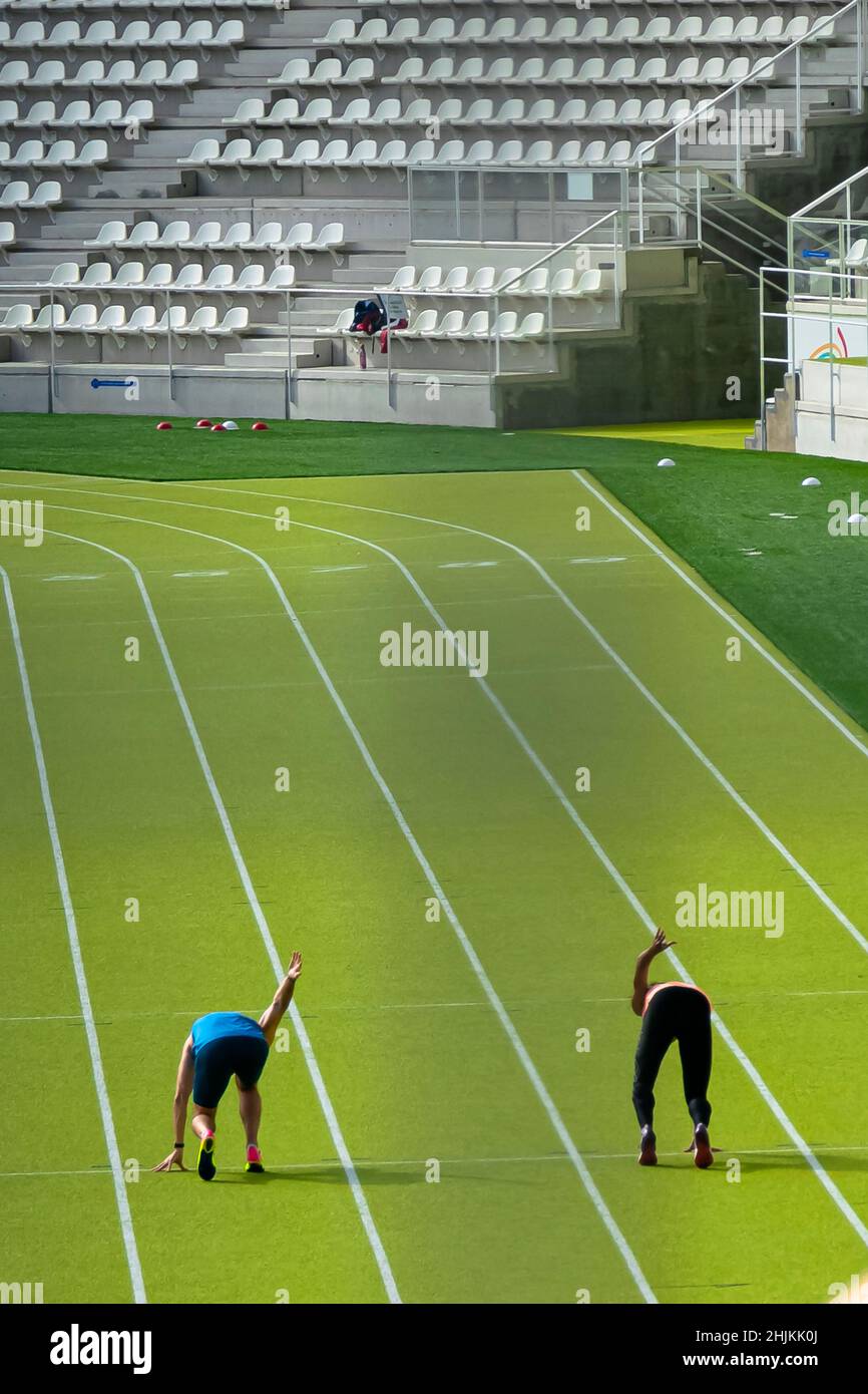 A man and a woman athletes rehearse the start at speed in a stadium ...