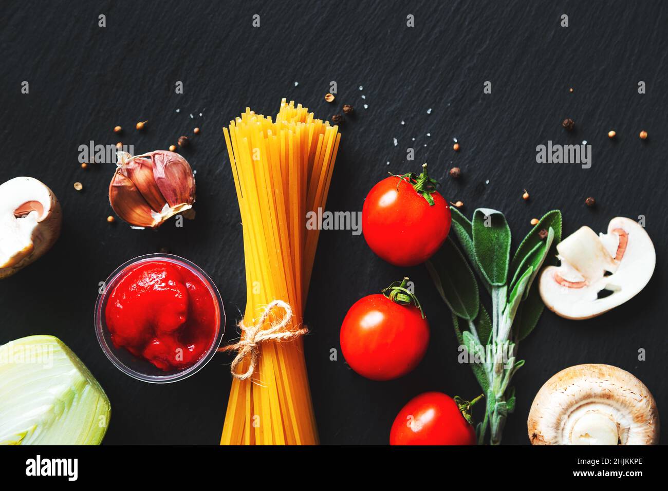 Spaghetti and various ingredients for cooking pasta. Black background ...