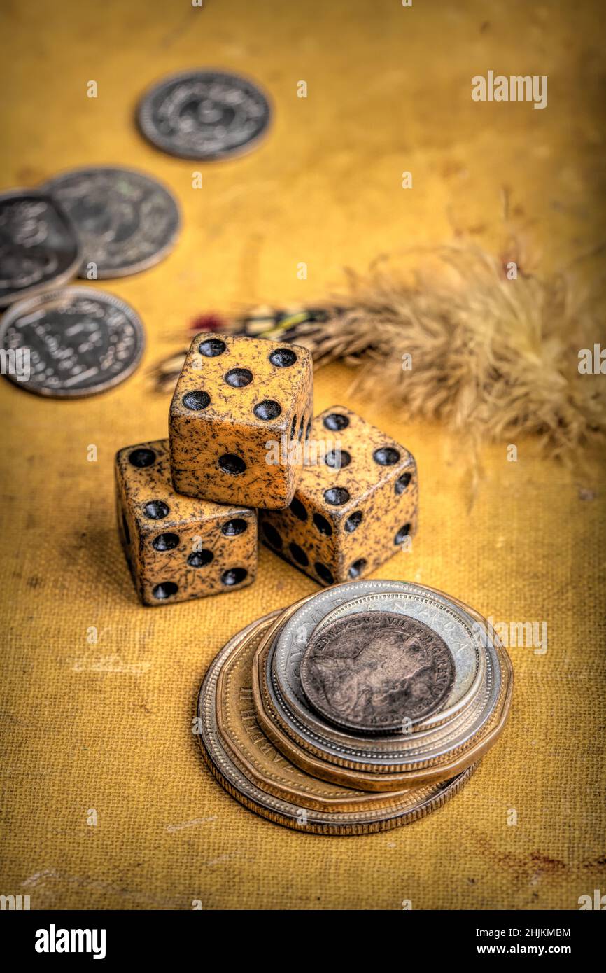 Vintage Dice, Old World Coins with feather in background Stock Photo ...