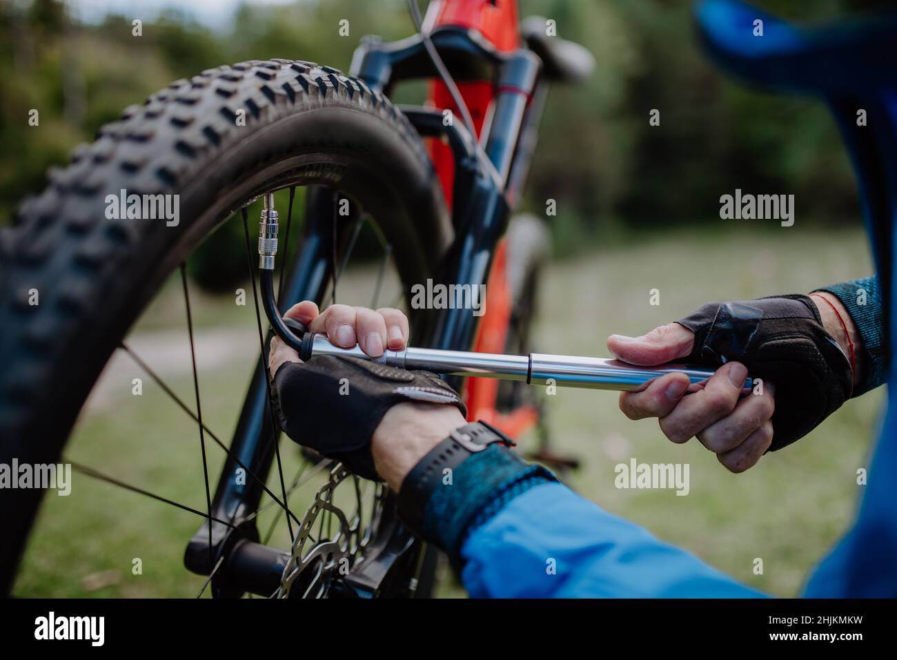 Close-up of a man pumping bicycle wheel in nature Stock Photo - Alamy