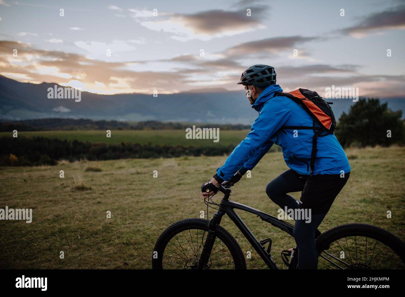 Side view of active senior man biker riding bike in nature on autumn ...