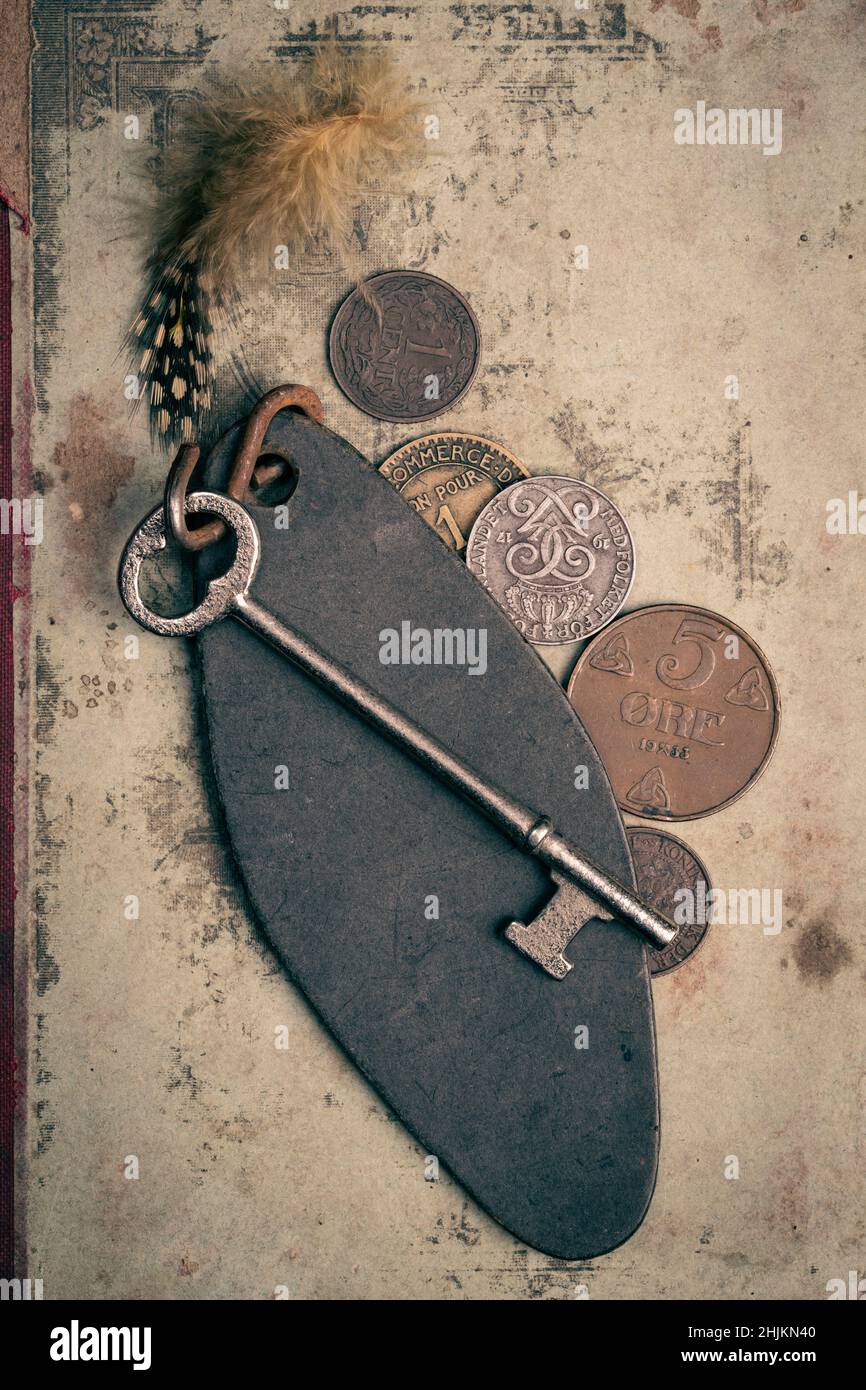 Skeleton Key on an old hotel room tag with old world coins flat lay ...