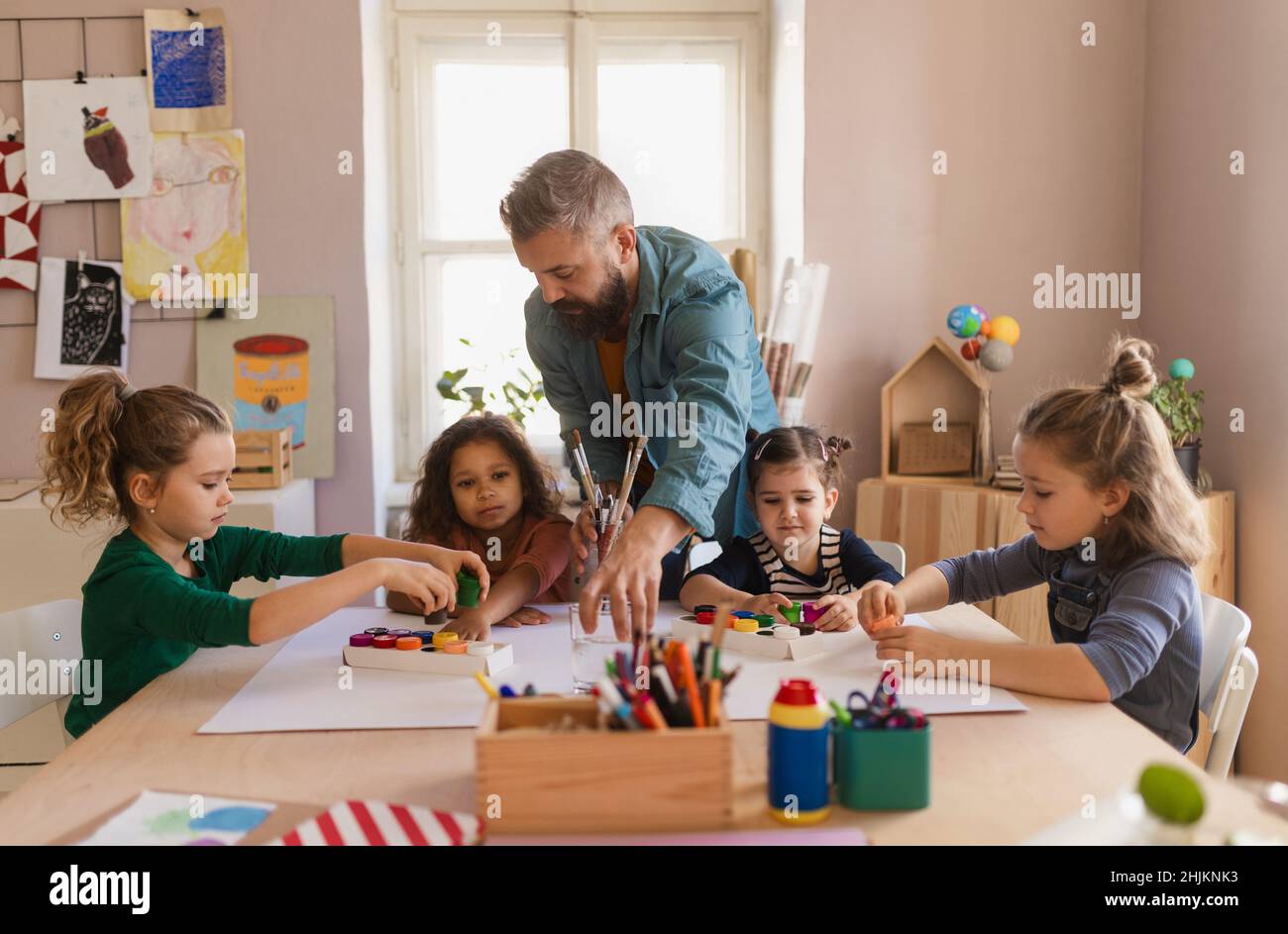 Group of little kids working on project with teacher during creative ...