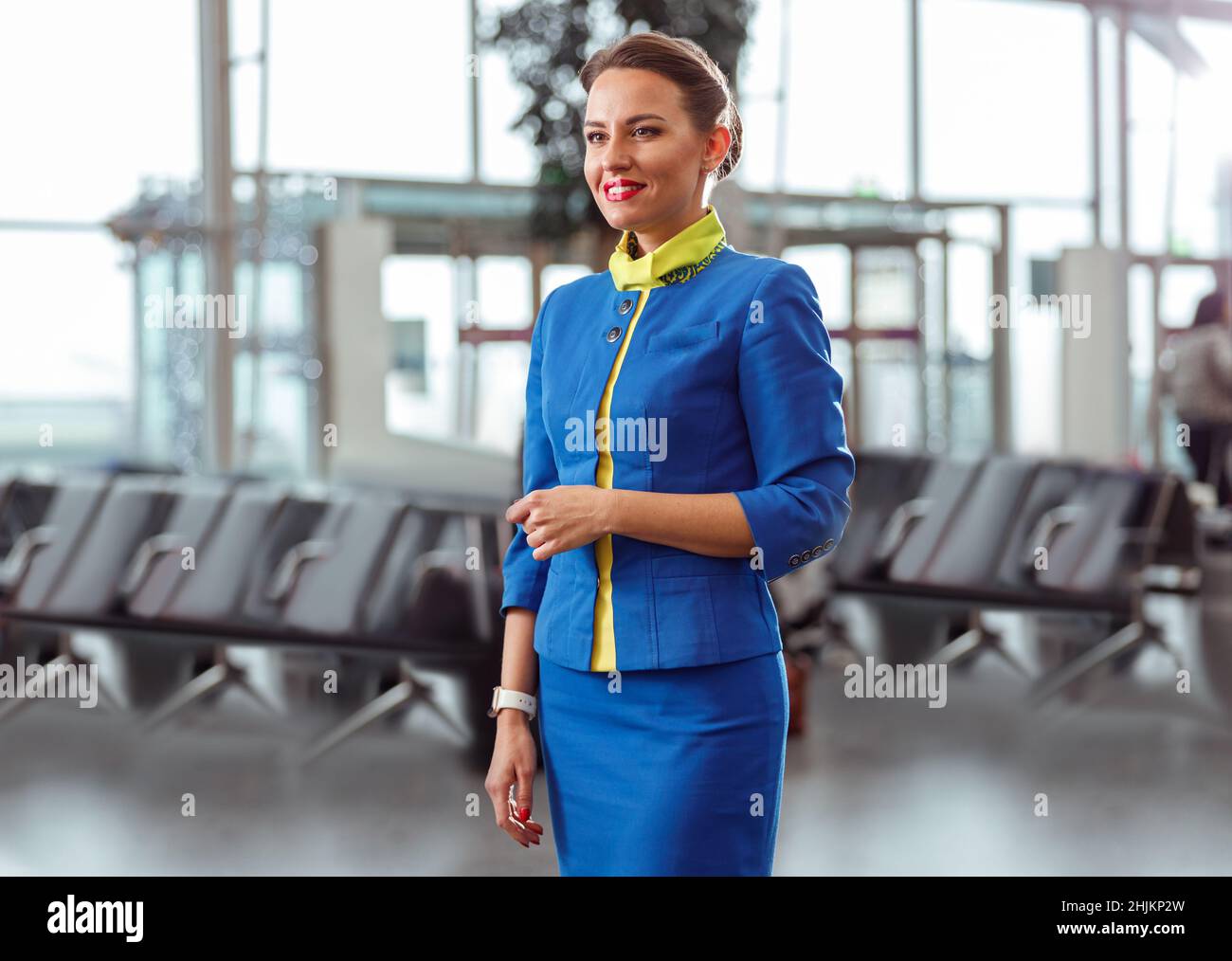 Joyful flight attendant standing in airport terminal Stock Photo - Alamy