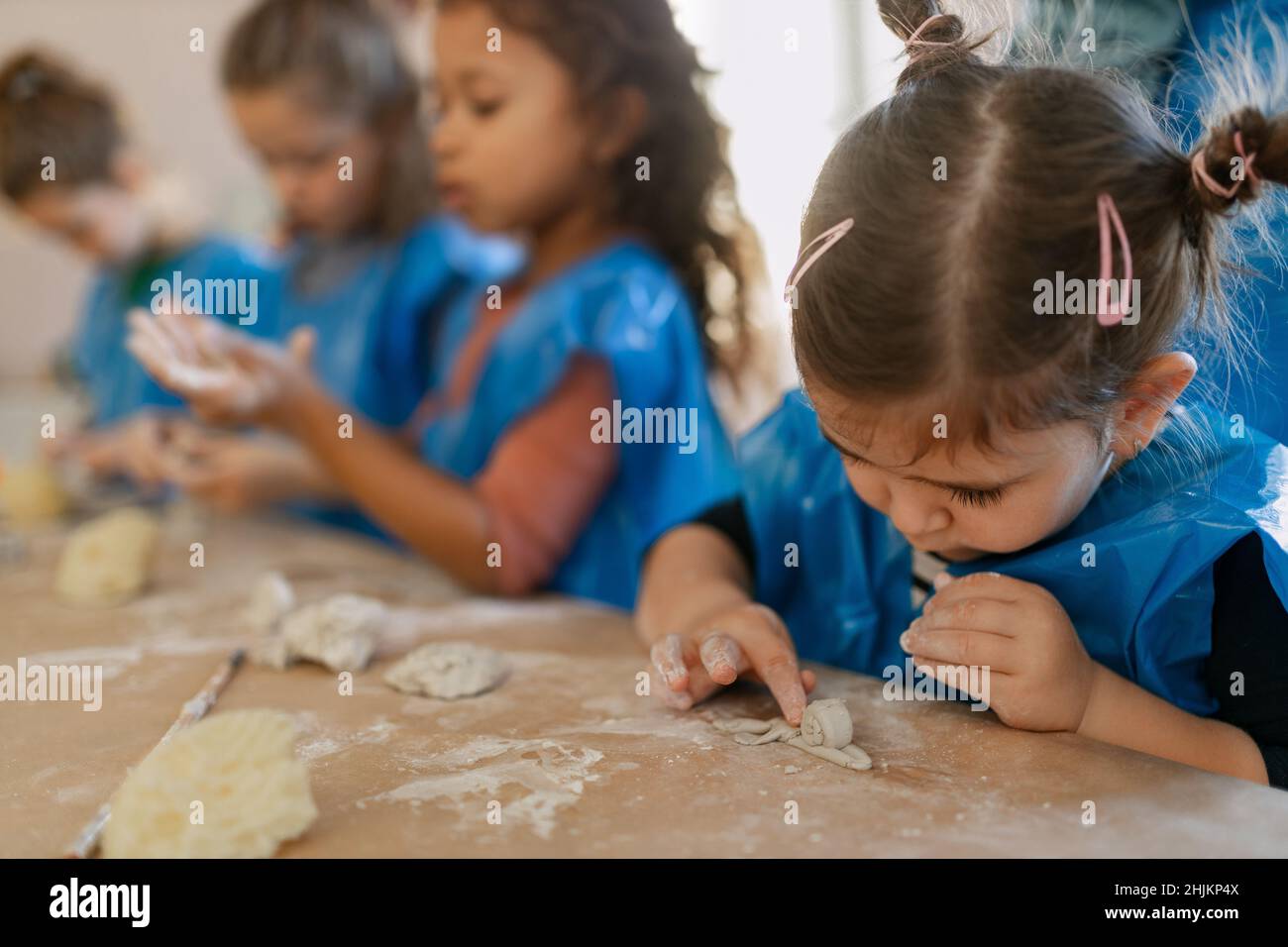 Group of little kids working with pottery clay during creative art and ...