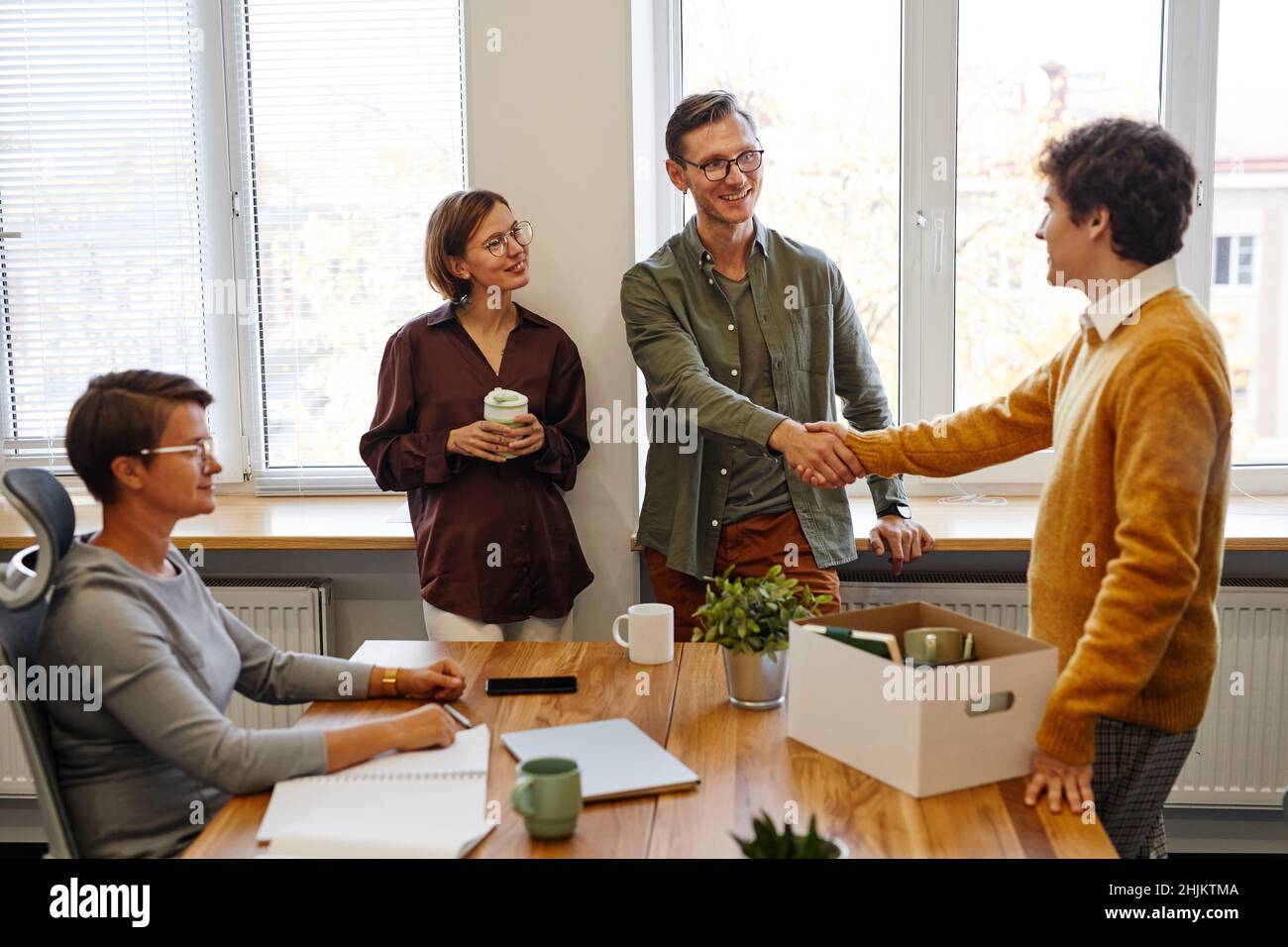 Group of smiling people welcoming new employee in office, career and ...