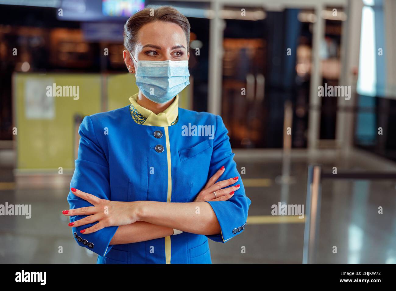 Stewardess in protective face mask standing in airport terminal Stock ...