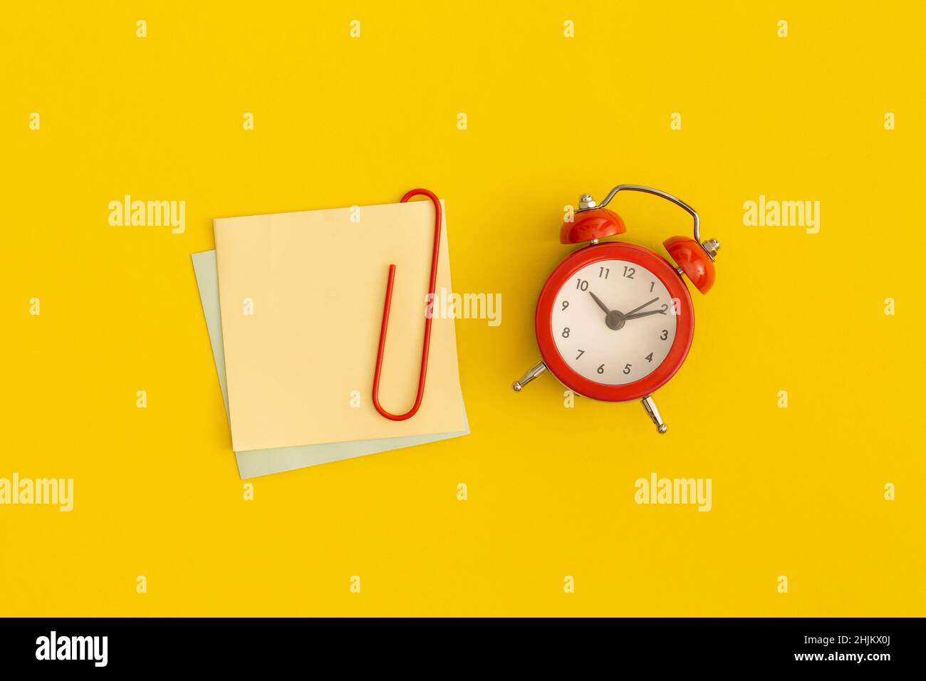 Red alarm clock and sticky notes with space for text on yellow ...