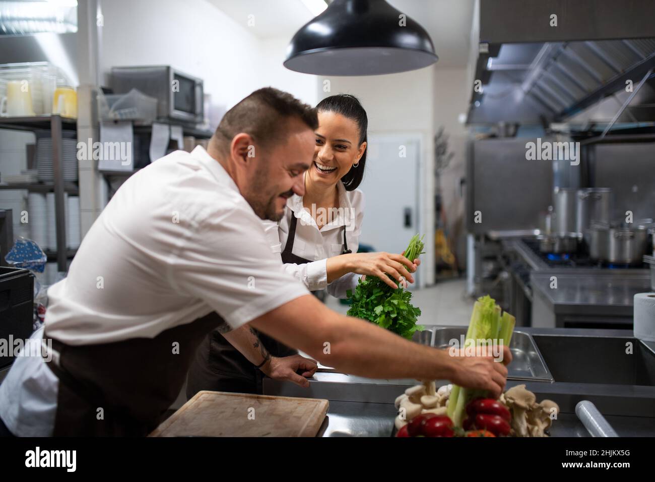 Chefs preparing vegetables for cutting in commercial kitchen Stock ...