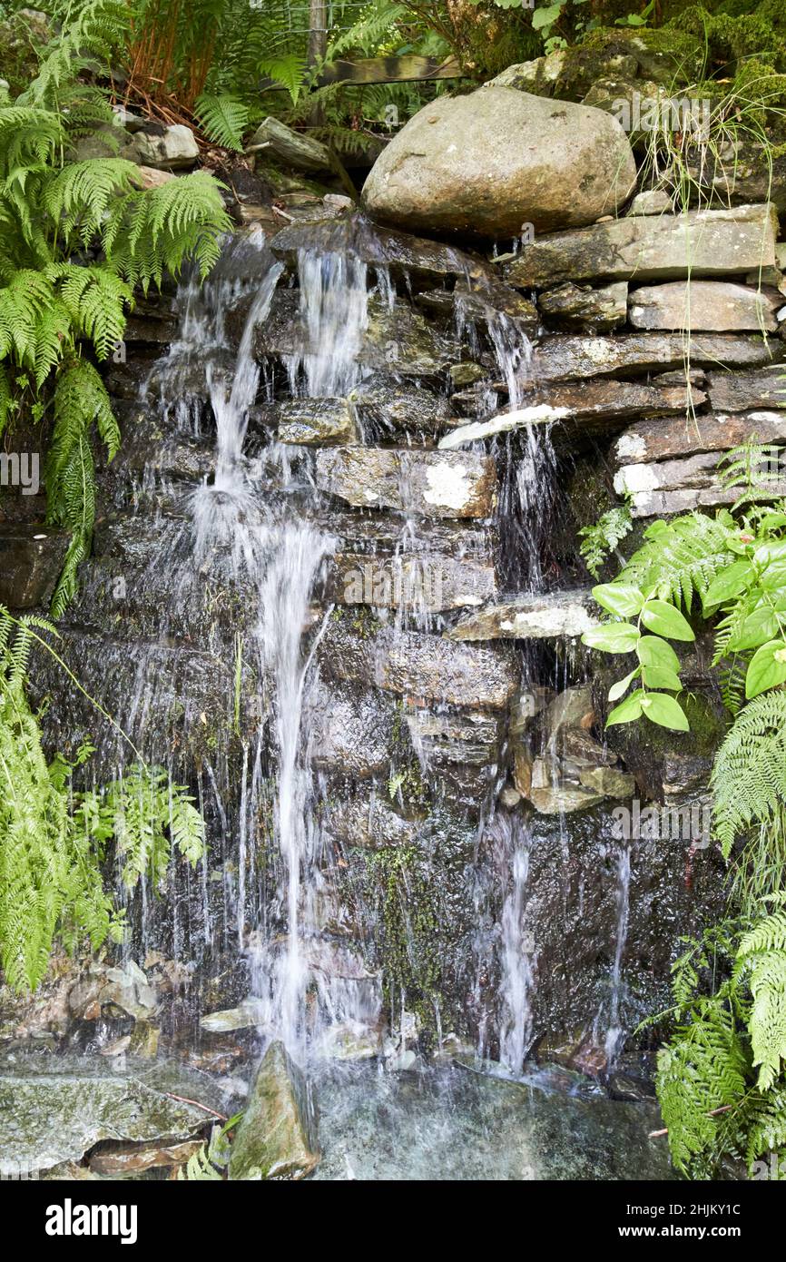 small stream flowing down rock wall small waterfall constructed from ...