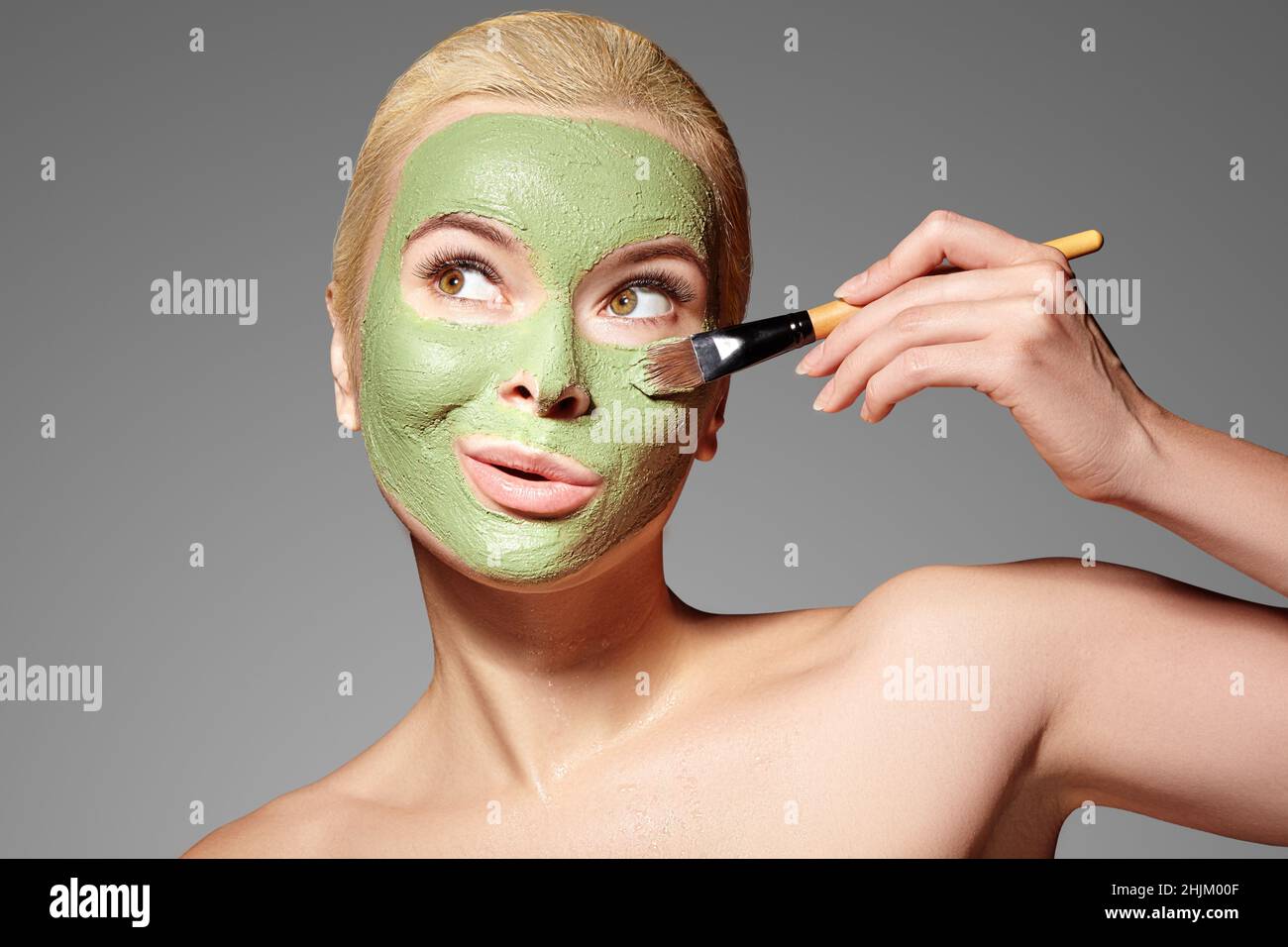 Beautiful Woman Applying Green Facial Mask. Beauty Treatments. Spa Girl Apply Clay Facial mask ...