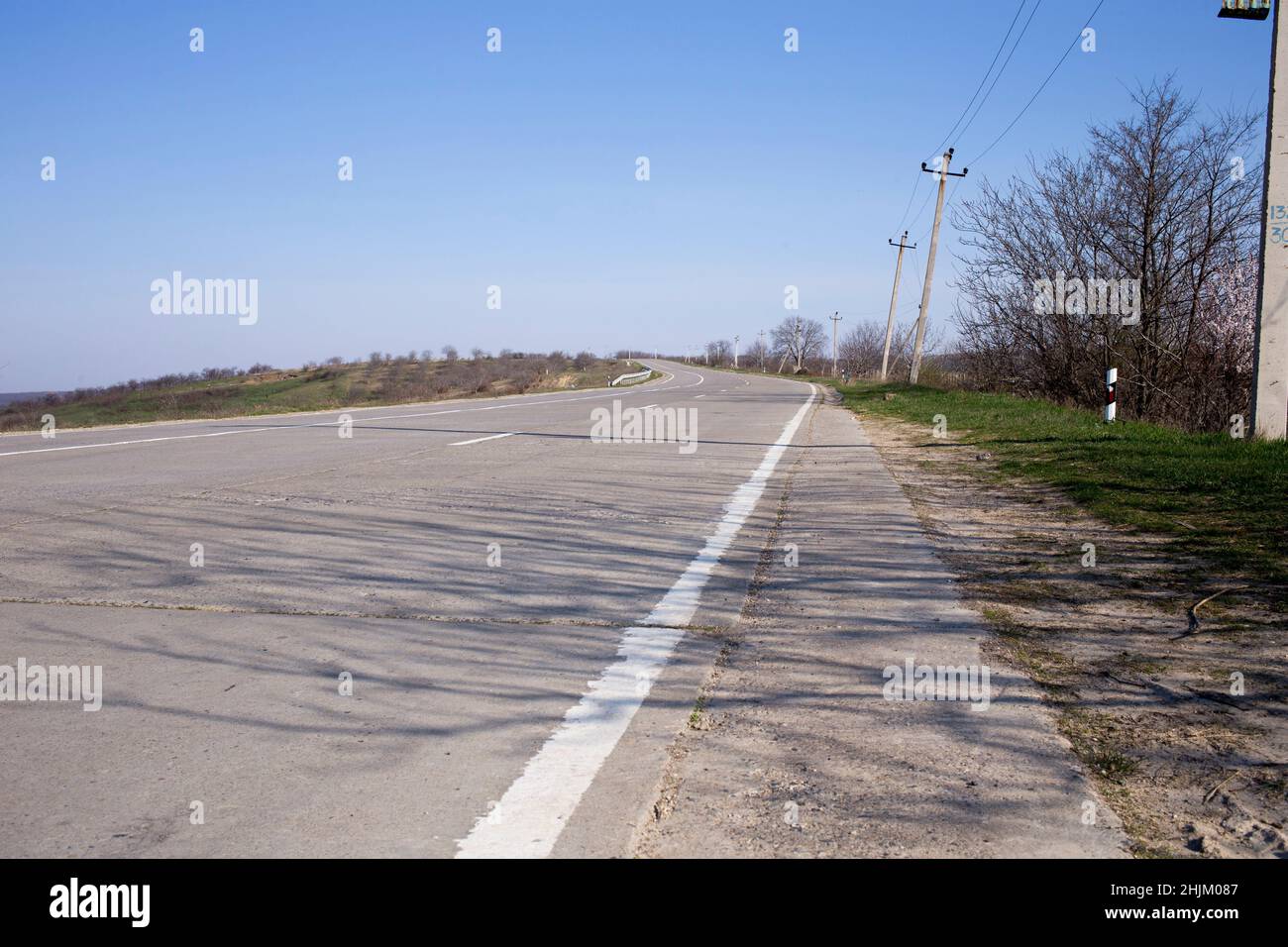 Main road outgoing to distance. Gray road and blue sky Stock Photo - Alamy