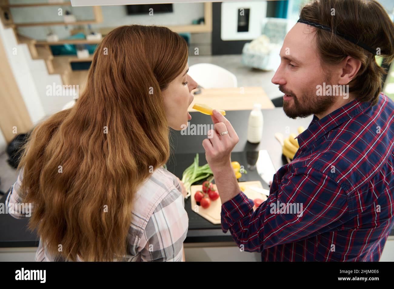 Rear view of a happy loving Caucasian couple enjoying cooking a healthy ...