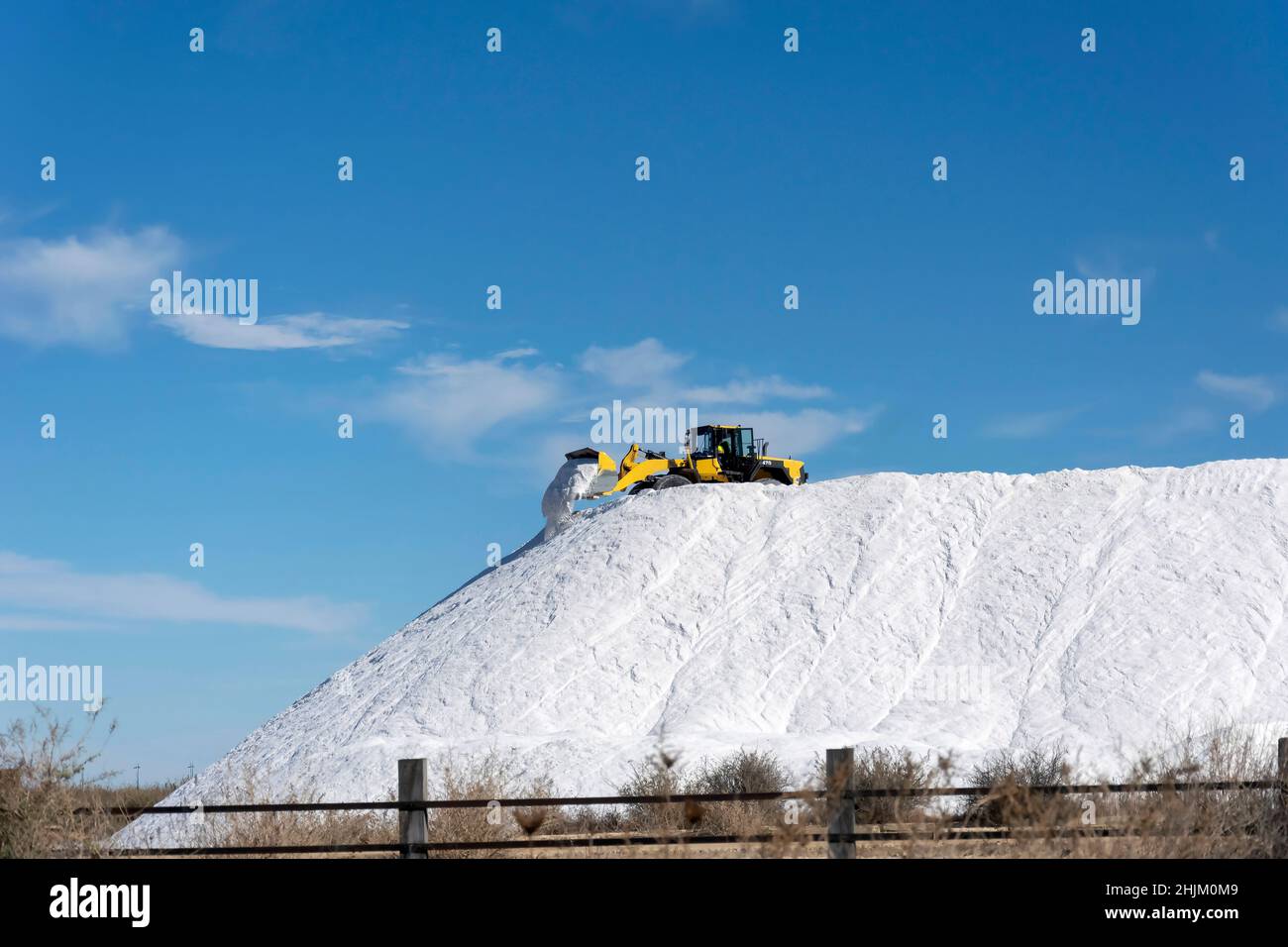 Excavator working in a huge pile salt at saltworks Stock Photo - Alamy