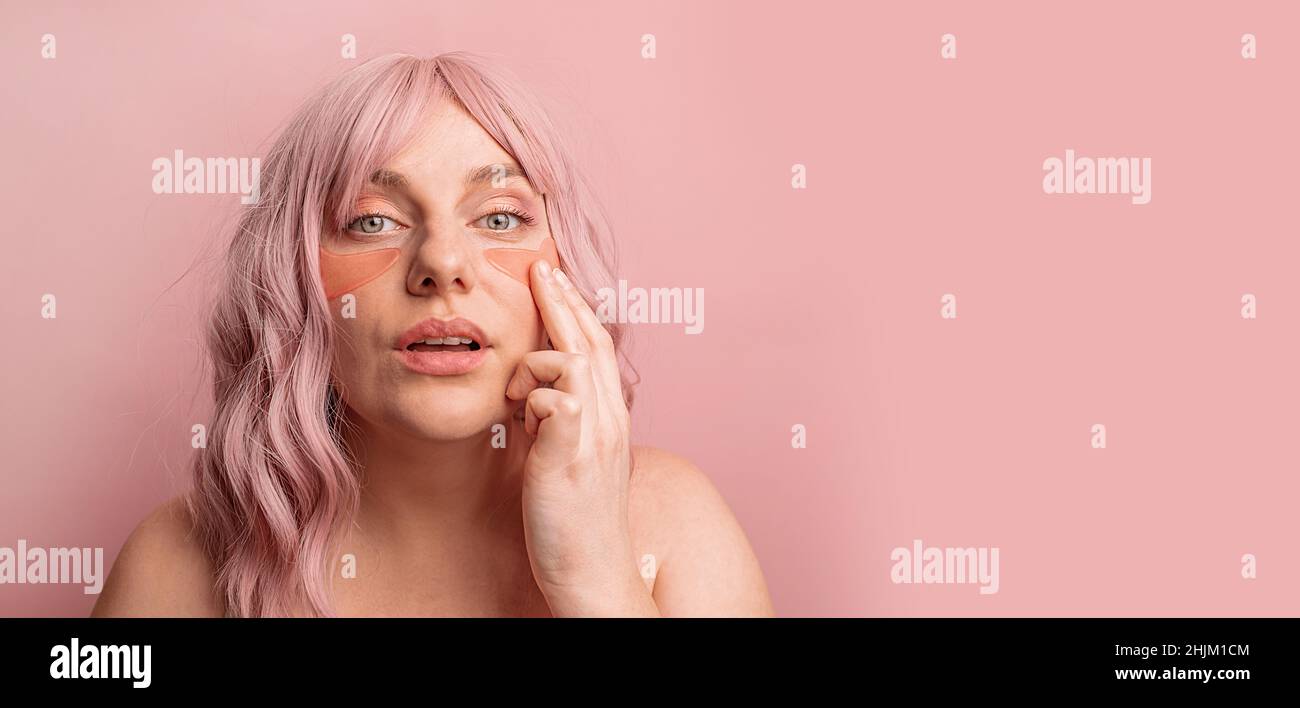 Portrait of happy caucasian female with closed eyes applying pink under ...