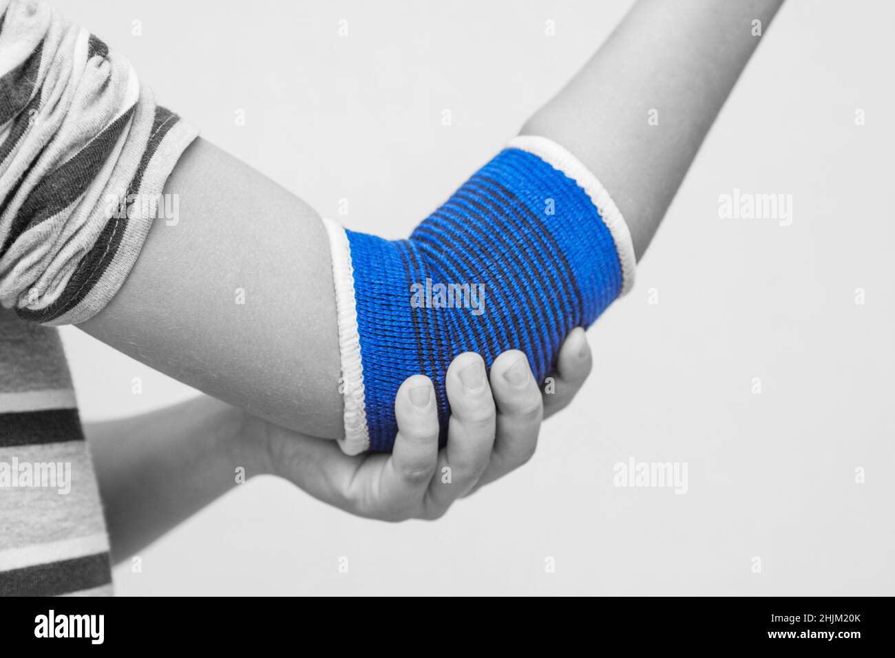 Elbow wrapped in elastic bandage, elbow pain. A child with a ...