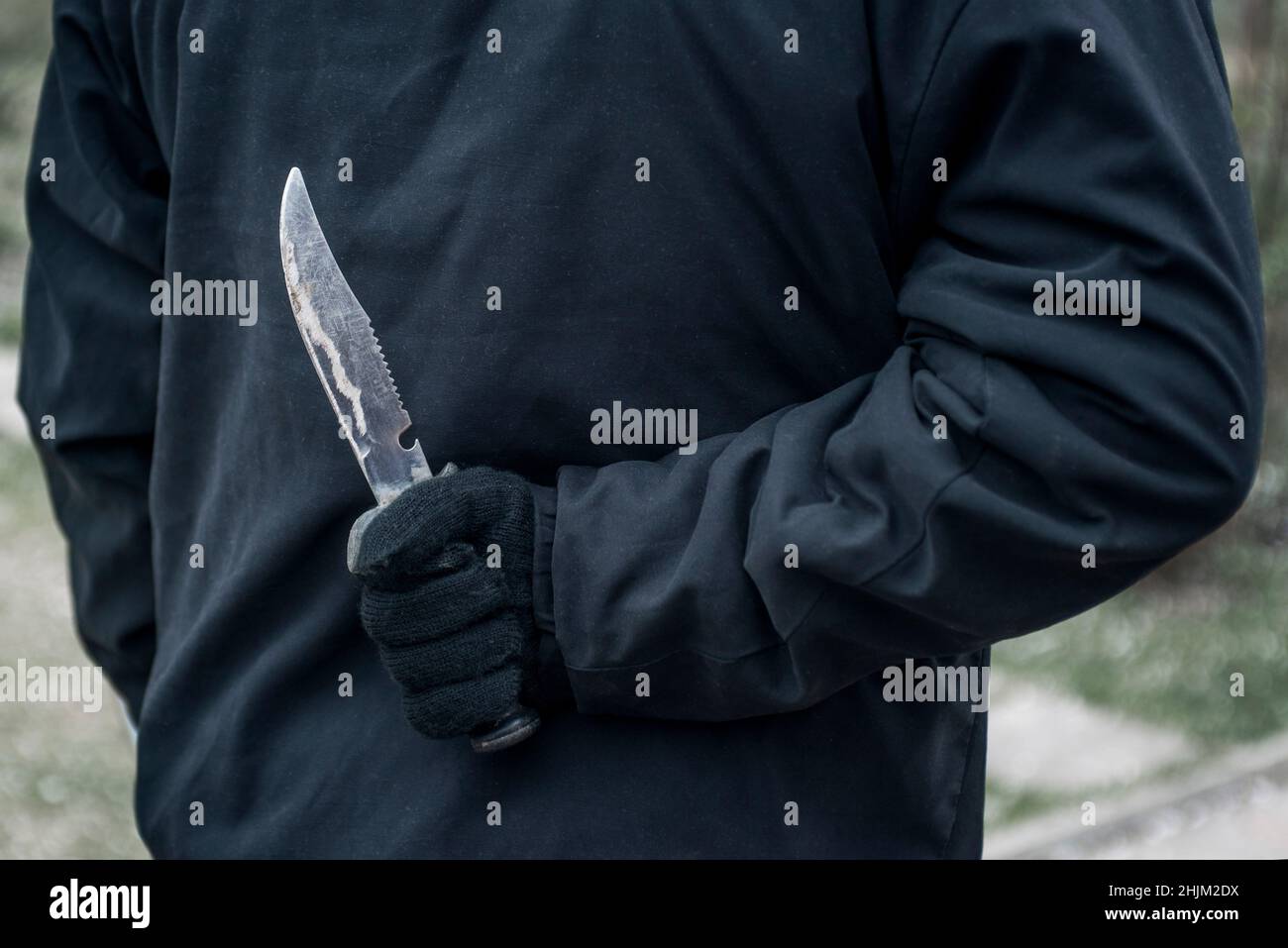 Man with the knife behind his back. Man holding sharp knife behind his ...