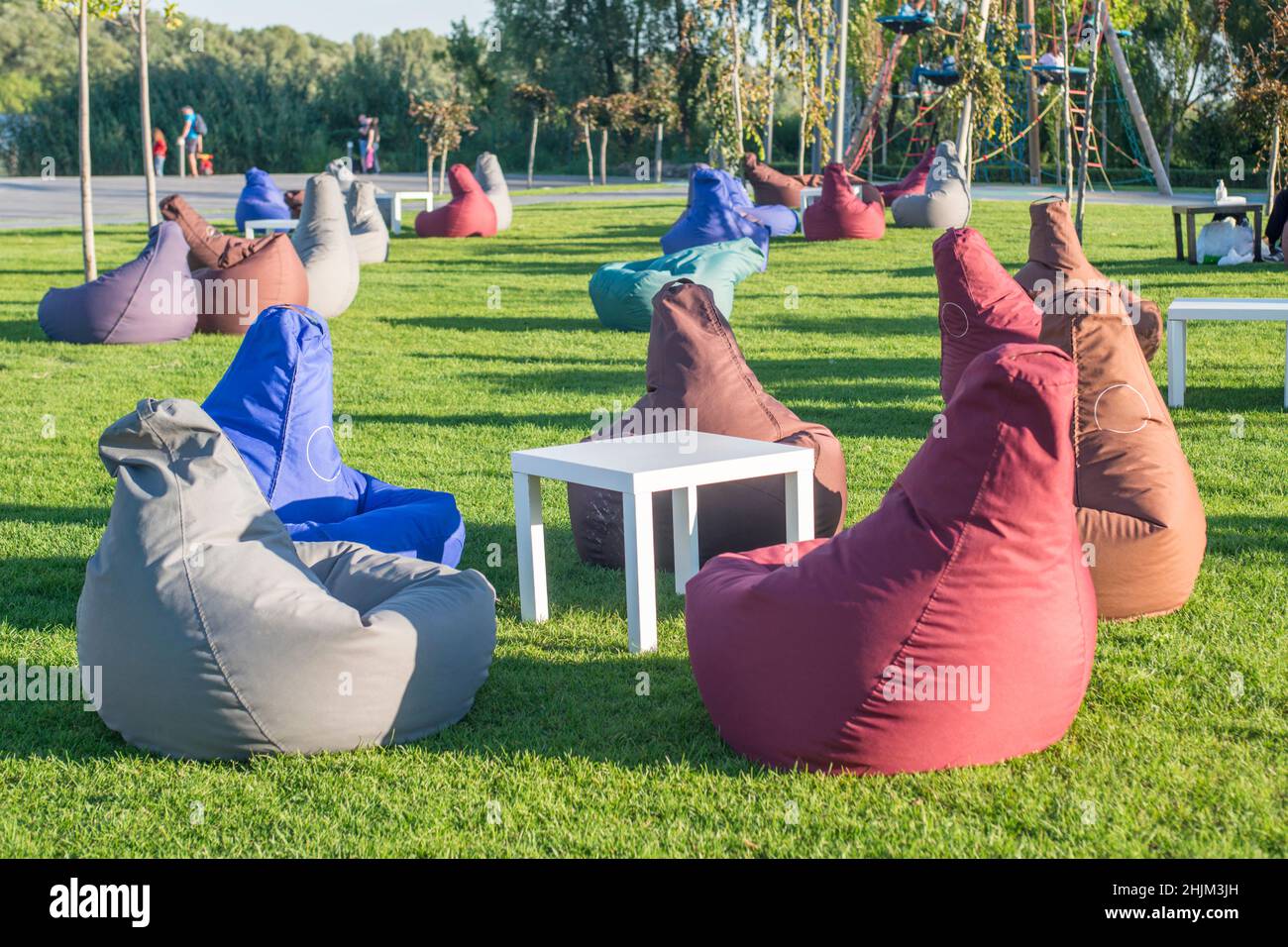 Many colorful bean bag seats to relax on grass outdoors. A convenient ...