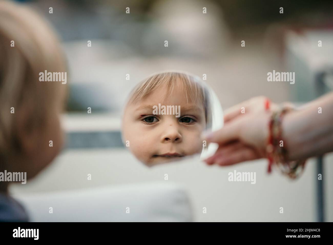Reflection of a cute little toddler boy, child, looking in mirror ...