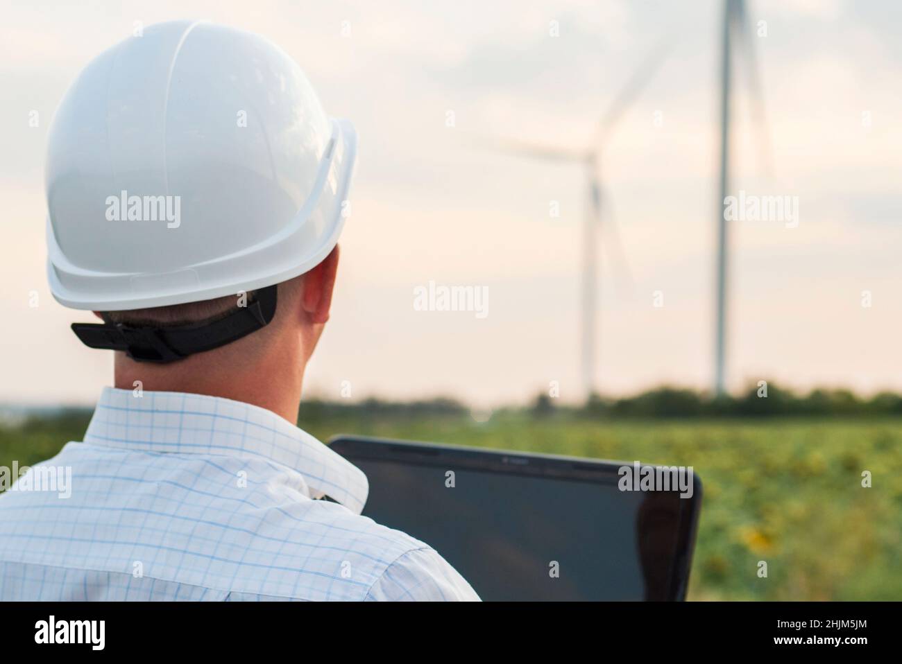 An electrical engineer is using laptop computer, checking on wind ...