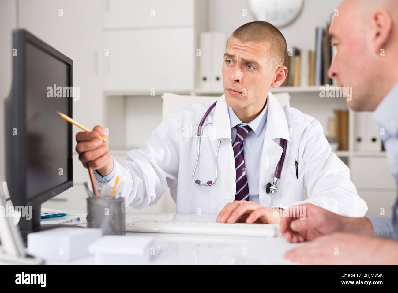 Male doctor in the clinic consults a patient in the office Stock Photo ...